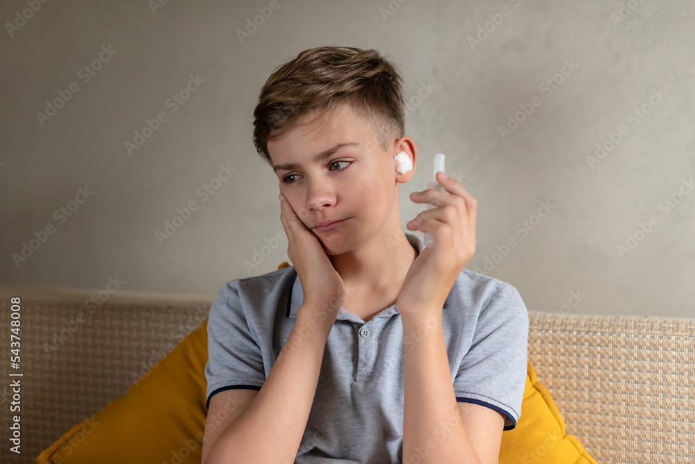 Teen boy suffering from strong earache or ear pain. Ear inflammation ...