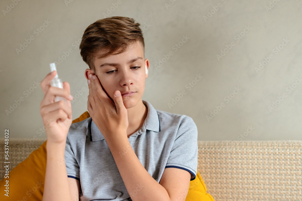 Teen boy suffering from strong earache or ear pain. Ear inflammation ...