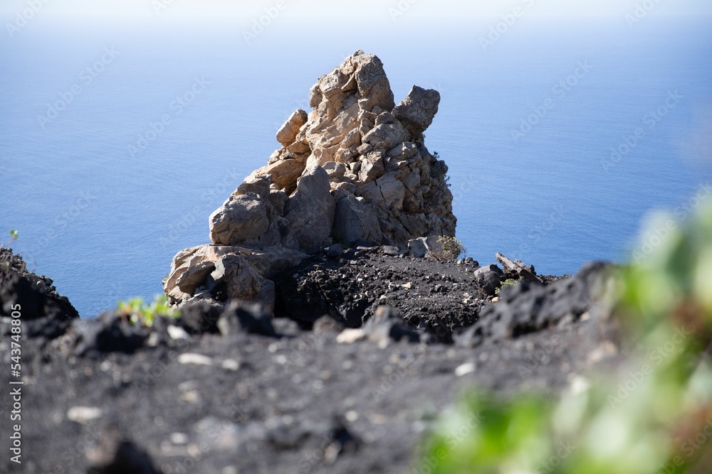 Rock formation at a coastline with blurred seascape in the background ...