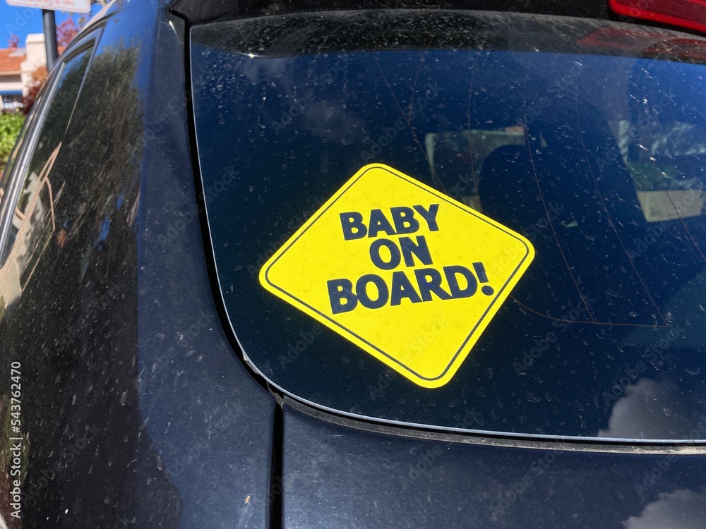 Baby On Board warning sign, yellow bumper sticker on the car rear door ...