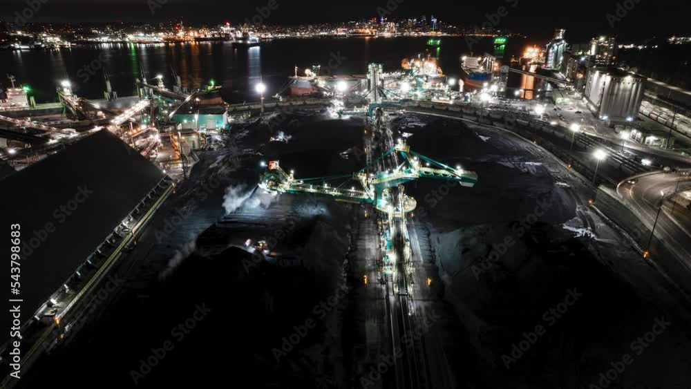 Rotary shovel at coal pile loading freight vessels at bulk shipping ...