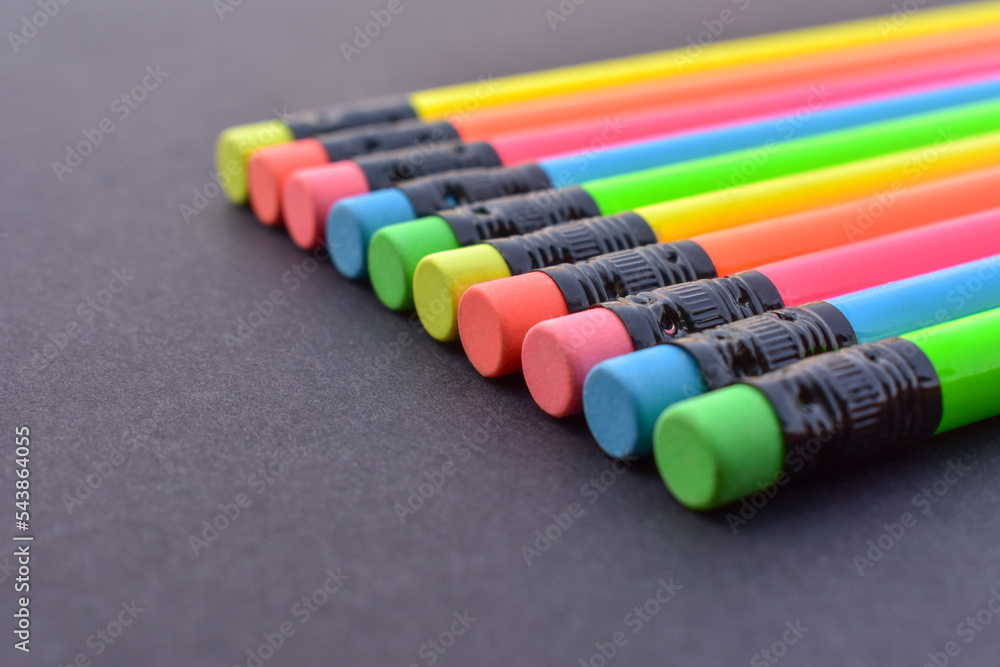 Multi colored pencils with rubber eraser on the black background. Back ...