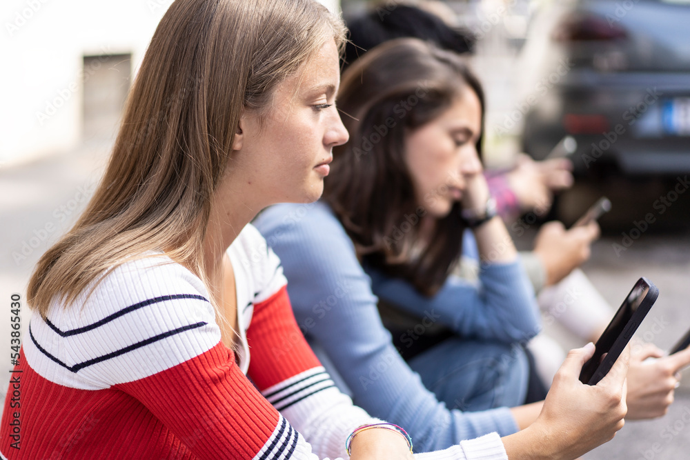 Bored friends group using smartphone sitting at university college ...
