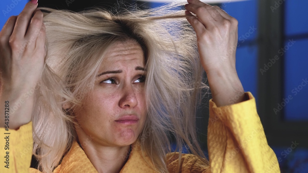 Damaged hair. Sad young woman with tousled hair. Close-up portrait of a ...