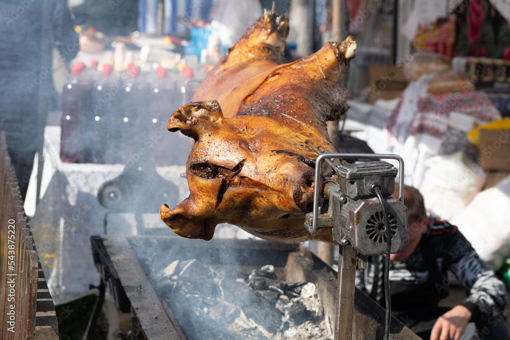 Piglet on a spit. Grilled pig at the street food festival. Roasted pig ...