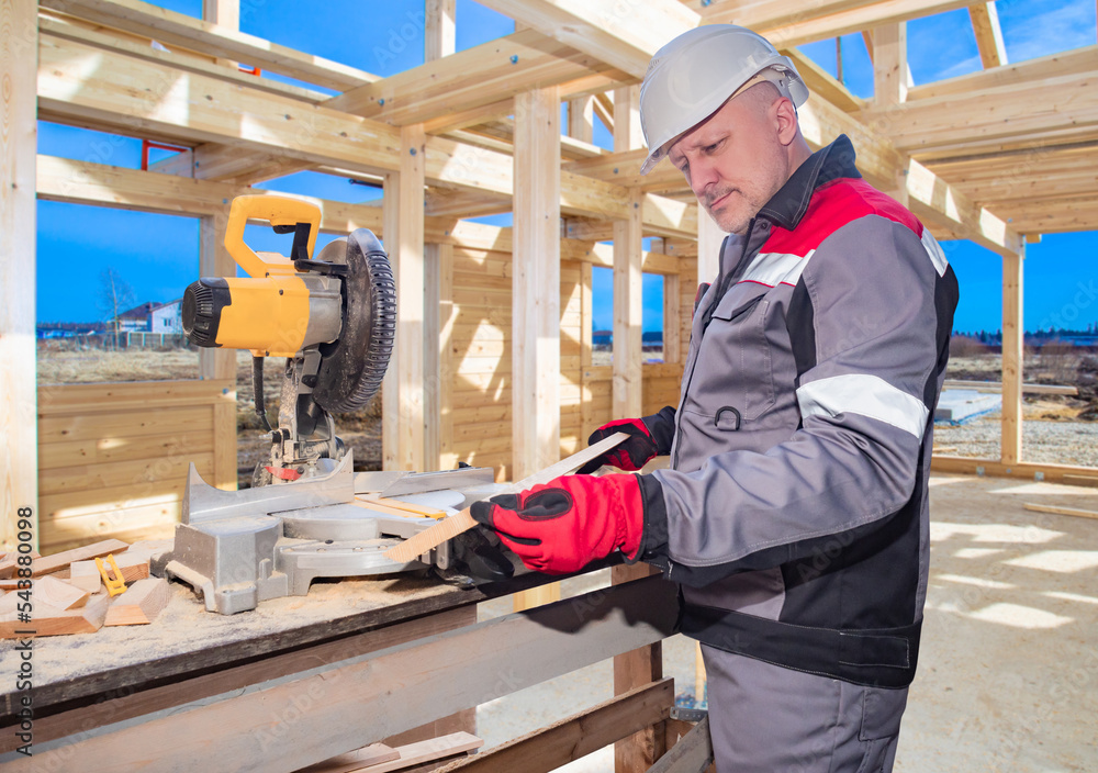 Construction of wooden house. Man builds frame cottage. Construction of ...