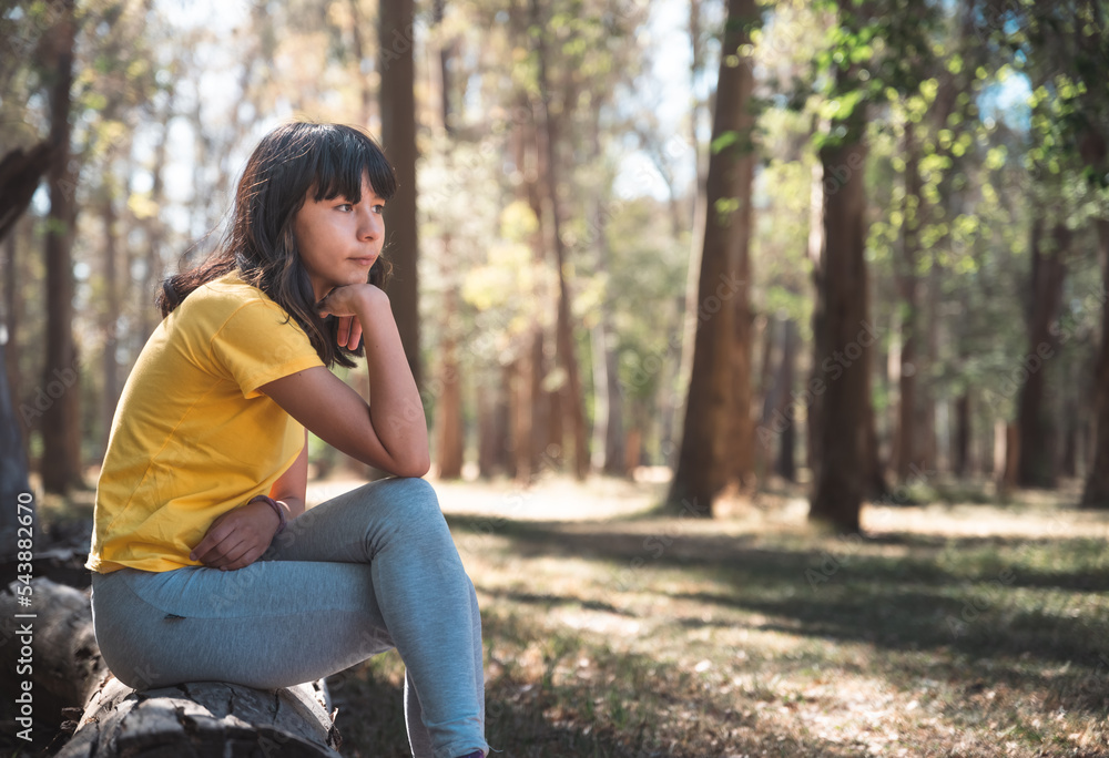 mujer sentada en tronco en el bosque Stock Photo | Adobe Stock