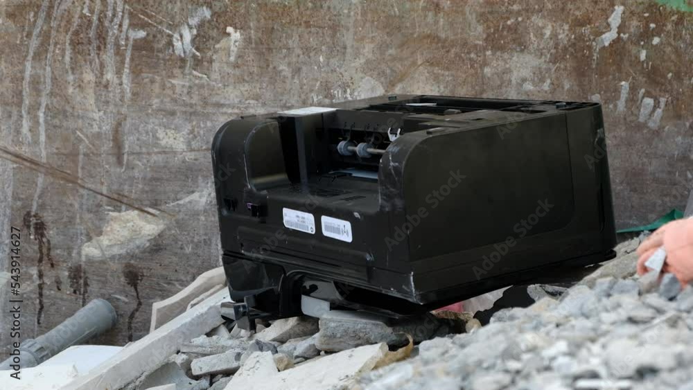 an old printer falls thrown away into a dumpster container with ...