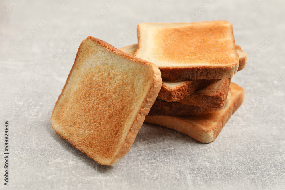 Slices of tasty toasted bread on light grey table Stock Photo | Adobe Stock