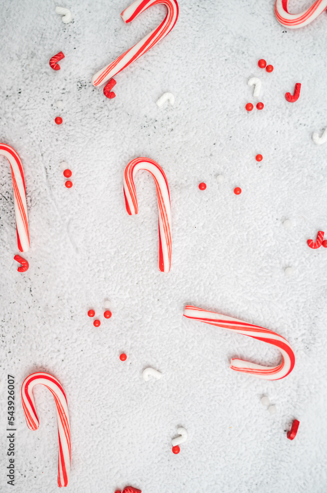 Candy canes and sprinkles scattered on grey background Stock Photo ...