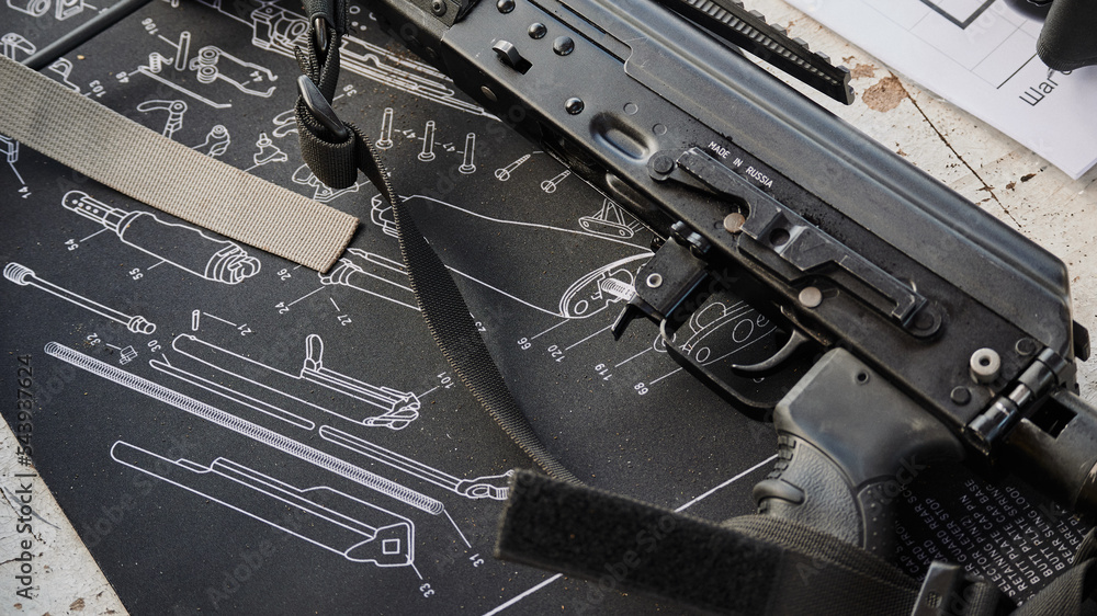 Trigger of a Kalashnikov assault rifle with a background depicting the ...