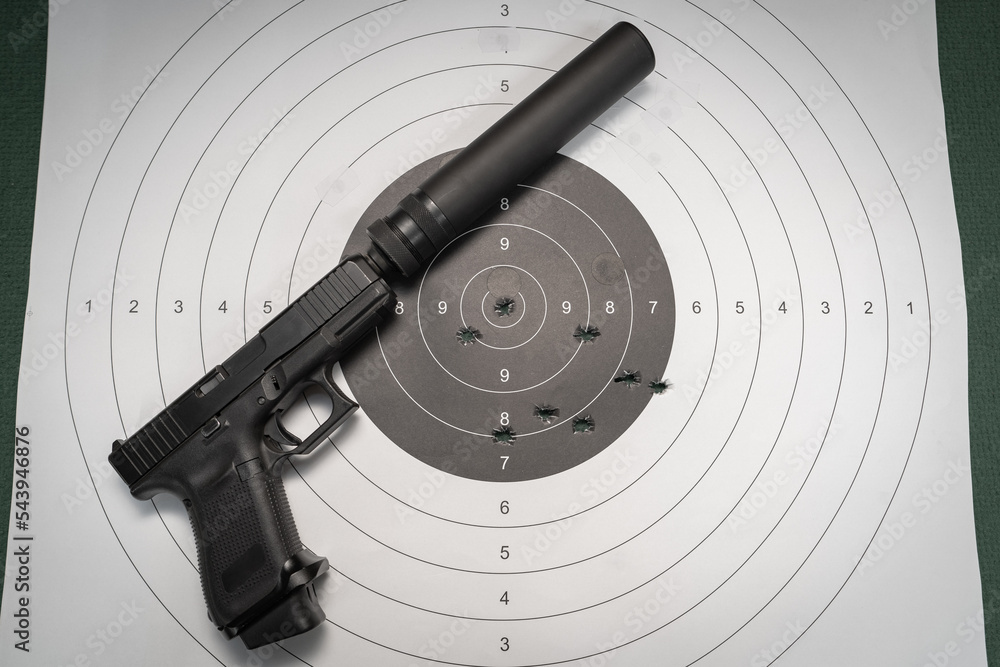 9mm pistol with silencer and target for shooting with bullet holes ...