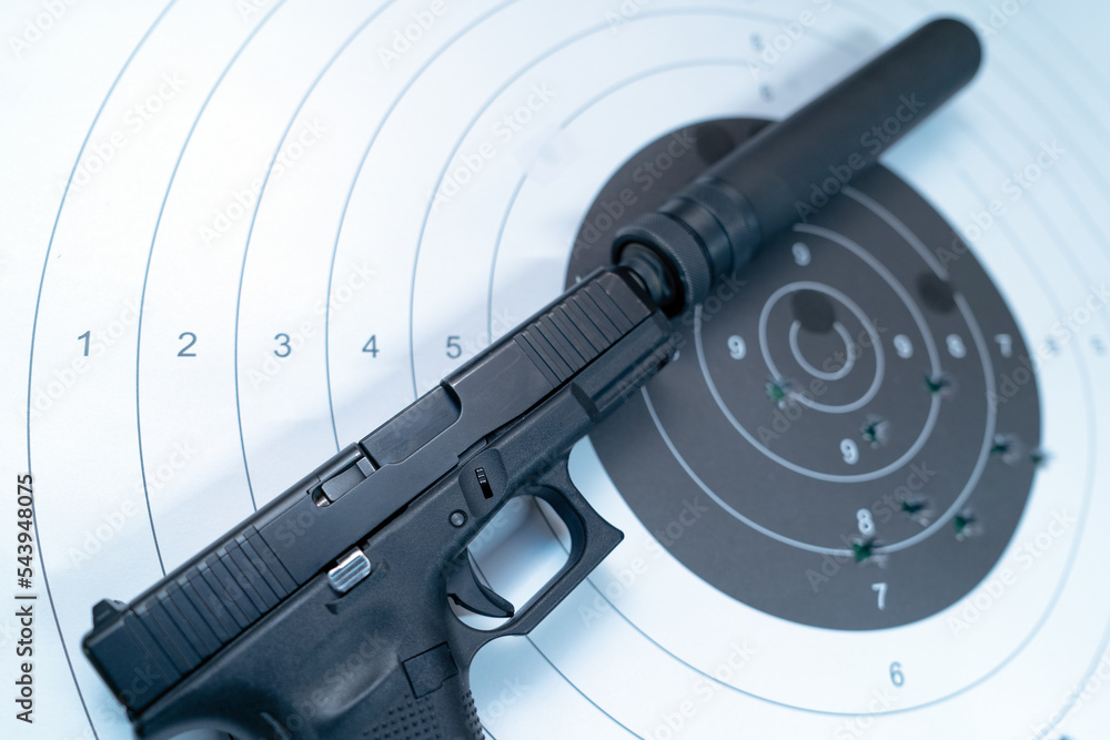 A pistol with a silencer and a target for shooting at a shooting range ...