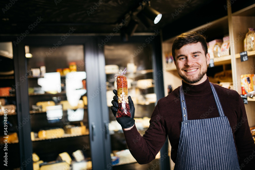 Dried fruits and nuts. Man holds the mix of nuts and raisins in bags ...