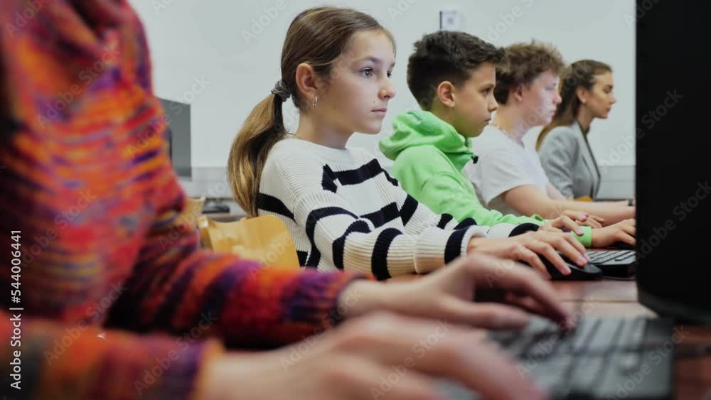 Portrait of interested tween girl during lesson in computer room of ...