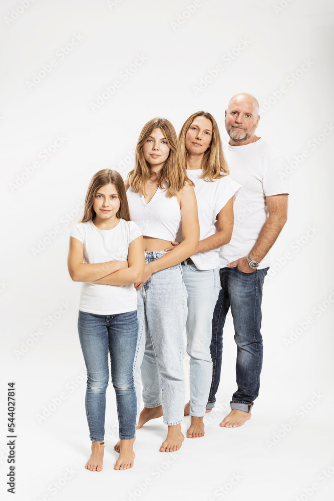 Confident family with two children standing in row at studio Stock ...