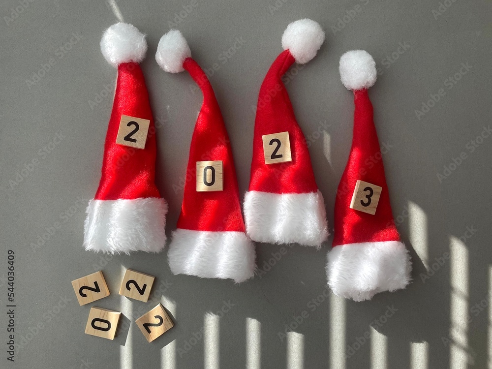 Four small Santa’s red hats with 2023 wooden numbers. Happy new 2023 ...