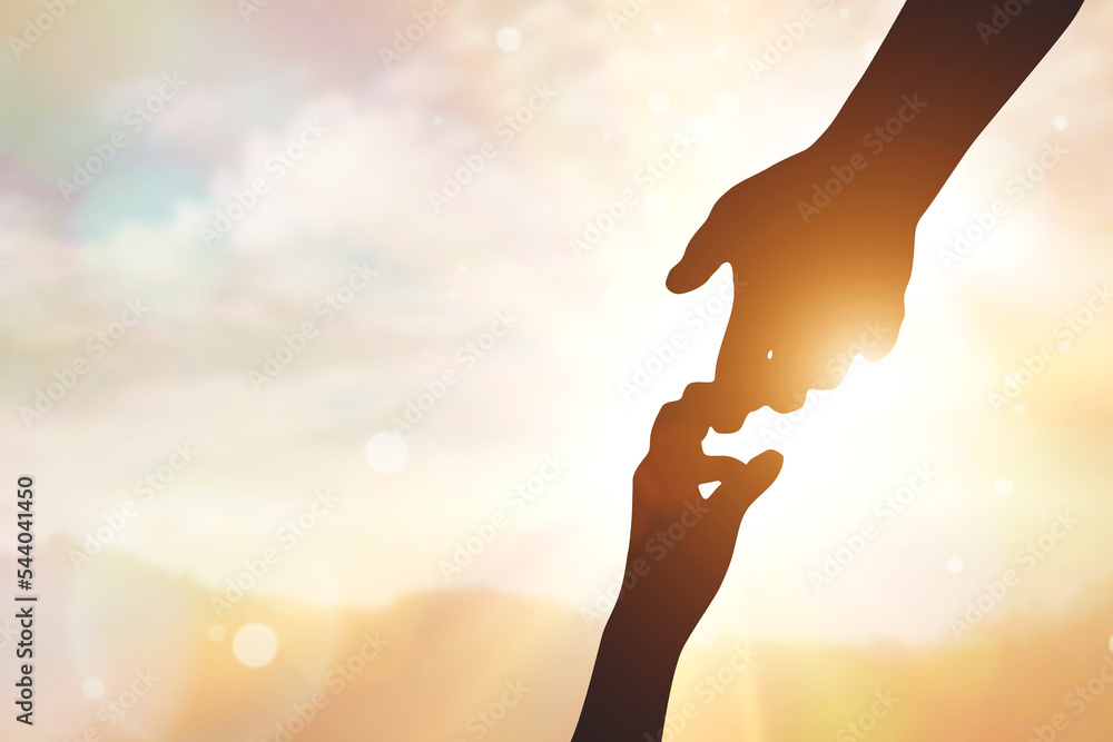 silhouette of two hands on sunset background, help concept, hope and ...