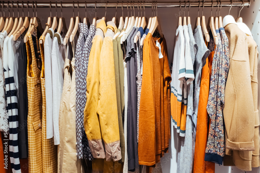 Collection of clothes in modern boutique. Clothes hanging on rack in ...