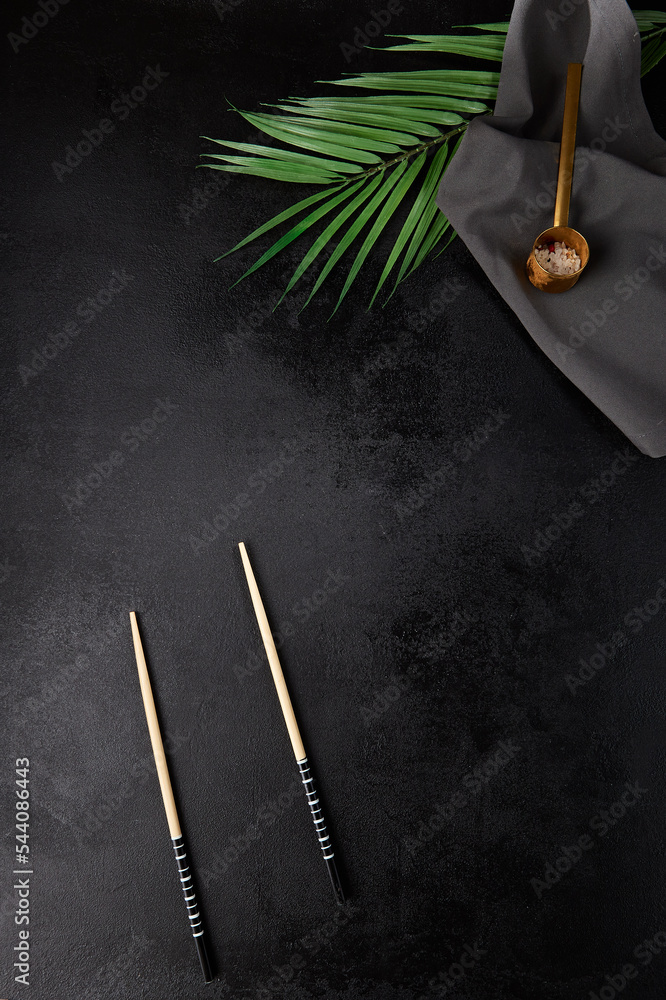 Dark food background with textile, palm leaves and chopsticks. Black ...