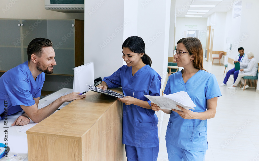 Medical employees. Medical assistant on duty talking with female nurses ...