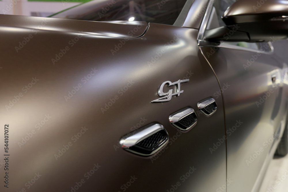 Lateral view of logo with detail of a luxury sports brown car Maserati ...