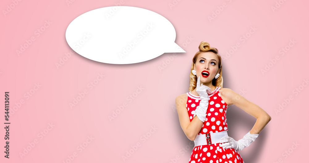 Studio portrait image of thinking woman in red pin up dress. Blond ...