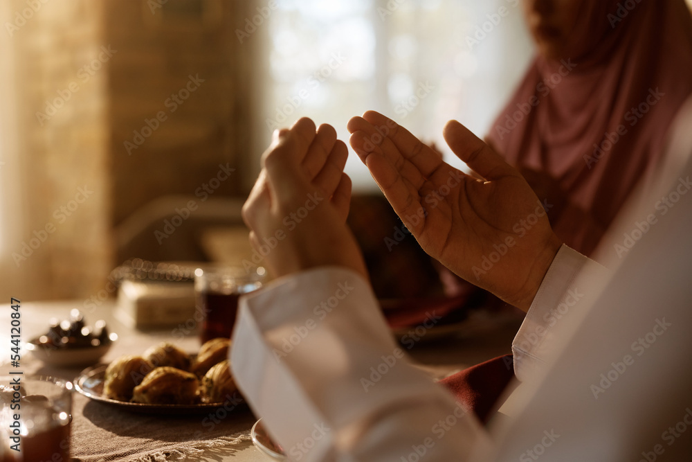 Close up of Muslim man praying with his wife at dining table. Stock ...