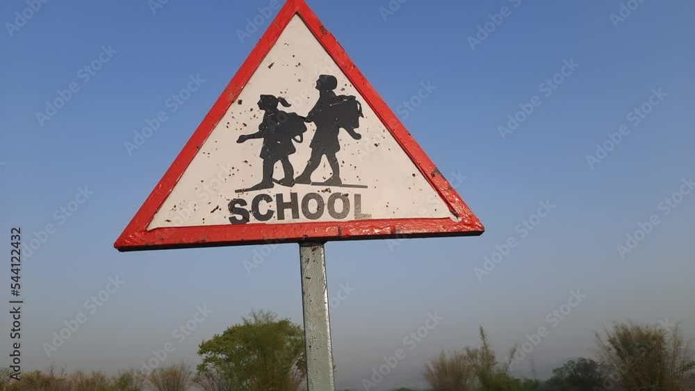School sign plate in the roadside. Triangular school ahead sign plate ...