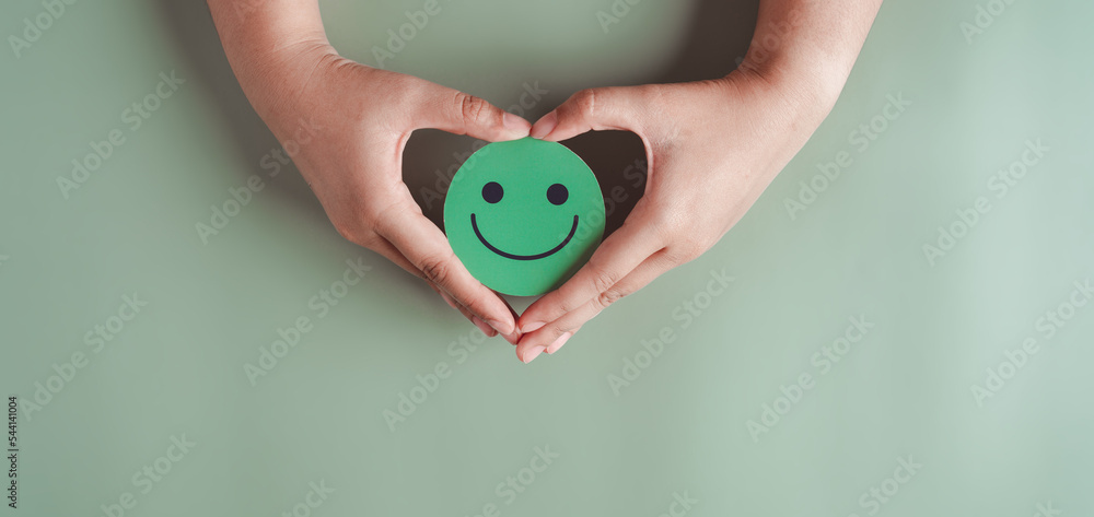 Hands holding green happy smile face, good feedback rating, positive ...