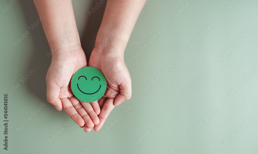Hands holding green happy smile face, good feedback rating, positive ...