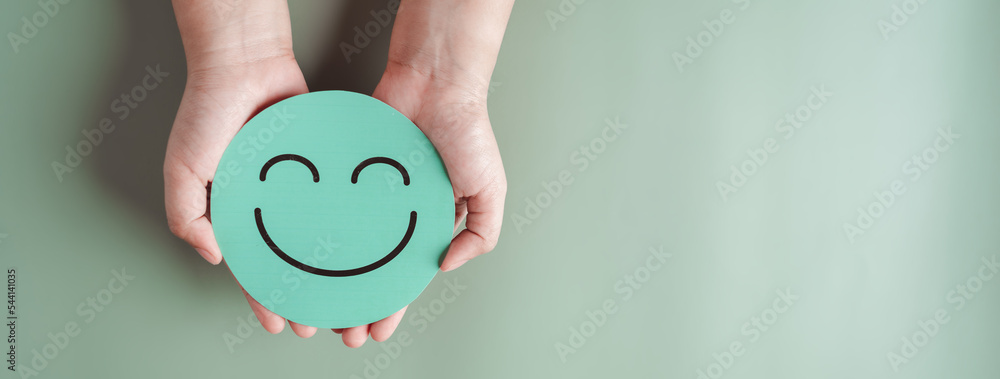 Hands holding green happy smile face, good feedback rating, positive ...