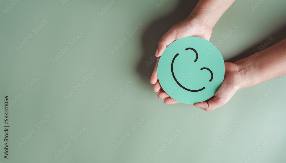 Hands holding green happy smile face, good feedback rating, positive ...