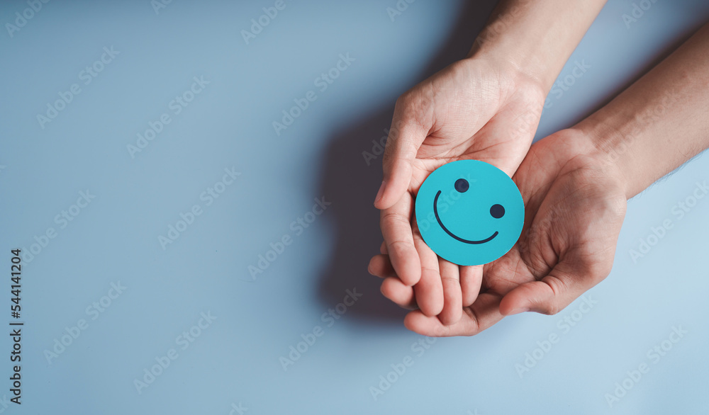 Hands holding blue happy smile face, good feedback rating, positive ...