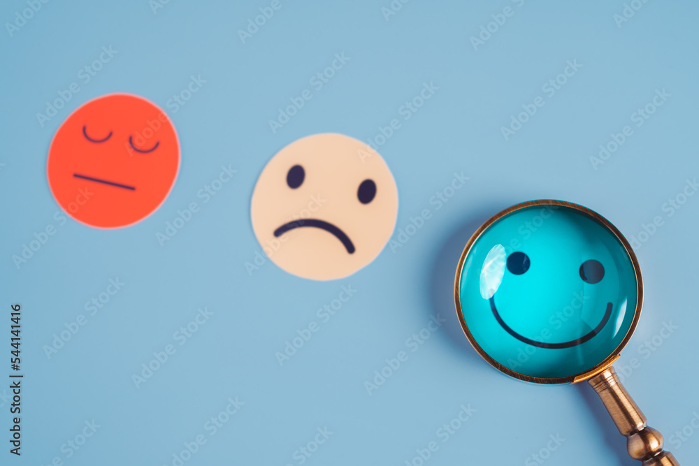 Hand holding magnifier focus selected happy smiley face paper cut which ...