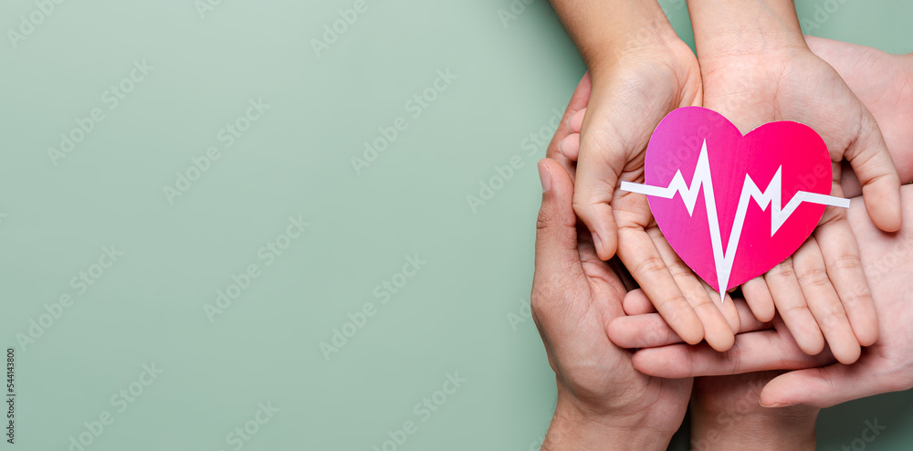 Adult and children hands holding red heart donation with pulse ...