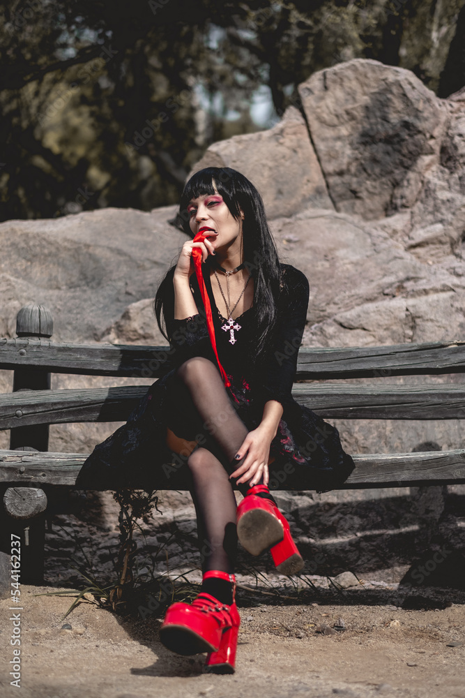 Young, sexy and vampiric hispanic goth girl with black dress and red ...