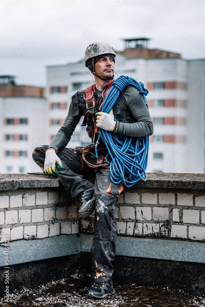 Male worker rope access industrial working at height tank oil wearing ...