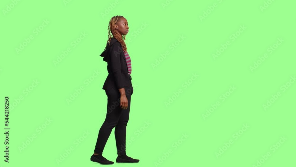 Casual woman walking on full body green screen backdrop, being relaxed ...