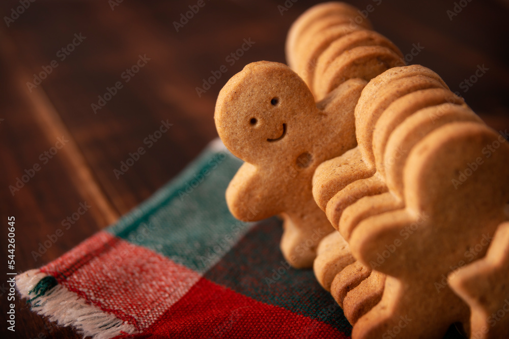 Homemade smiling gingerbread man cookie peeking out from a row of ...