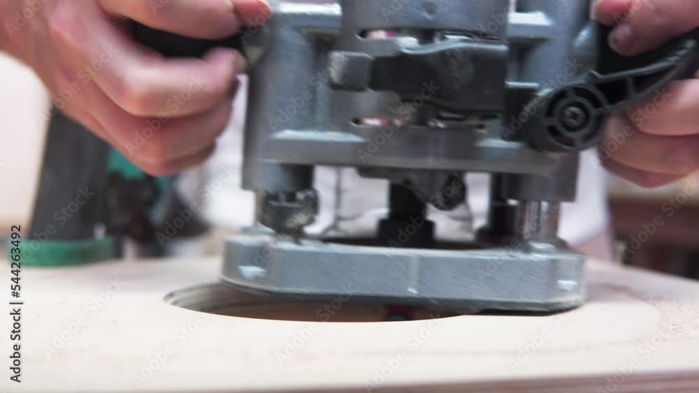 Artisan luthier using electric wood router machine to carve musical ...
