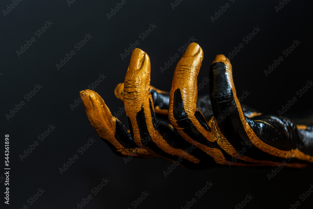 Elegant female hand with black and gold paint on her skin with black ...