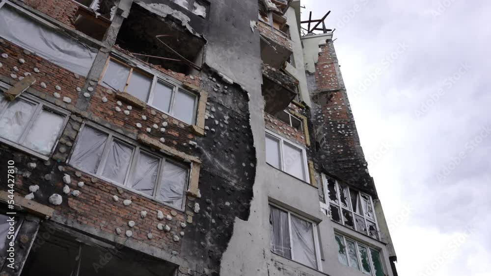 Live camera moves up along demolished house at background of cloudy sky ...