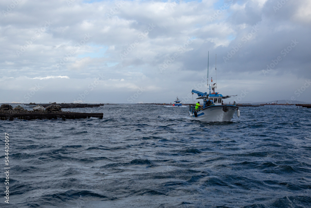 Inshore fishing sailors fish in their traditional wooden boat in the ...