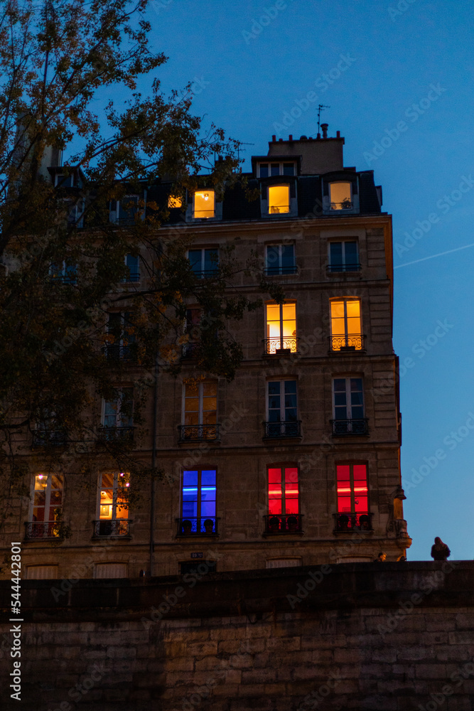 París noche. Luces de colores en las ventanas de un edificio de París ...