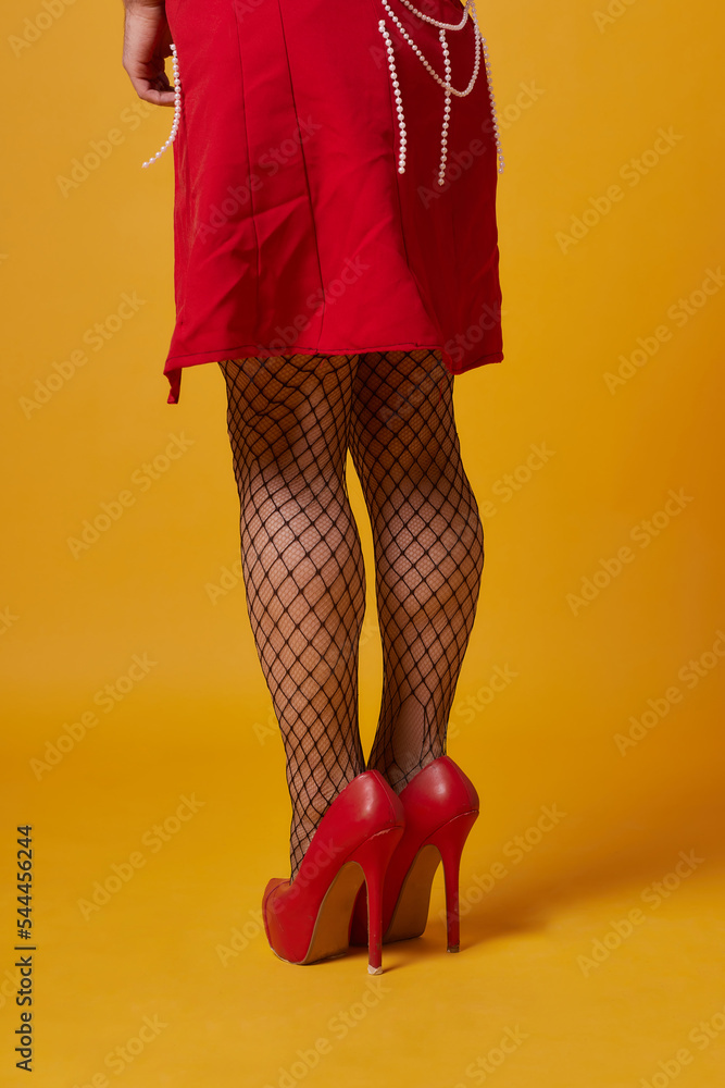 legs of a man putting on a woman's stocking while dressing up as a drag ...