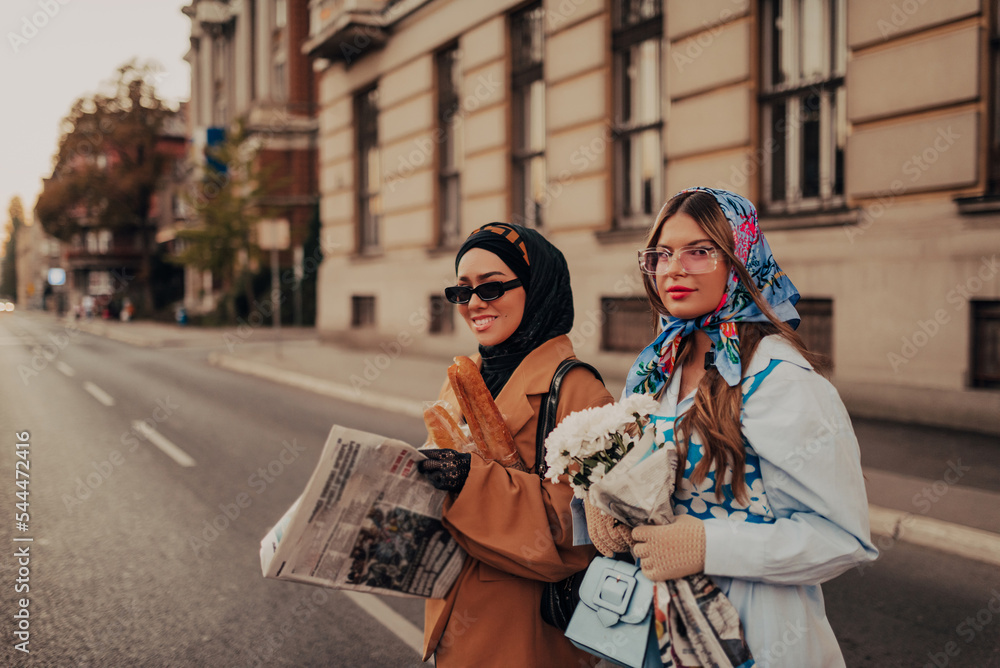 Foto de A modern European woman and a Muslim woman with a hijab walking ...