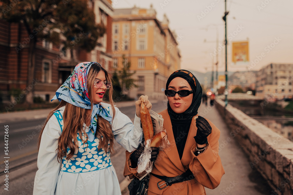 A modern European woman and a Muslim woman with a hijab walking the ...
