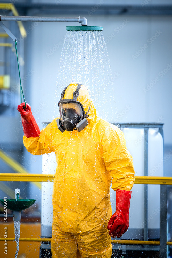 Chemical worker taking a shower and washing off aggressive chemicals ...