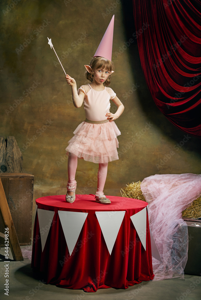 Magic. Little cute girl, kid in image of magical elf posing over dark ...